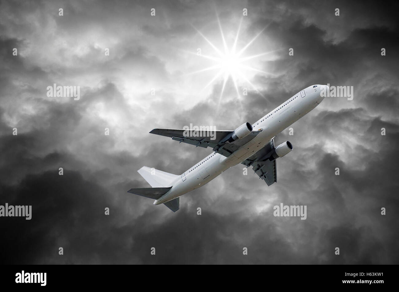 airplane under Sun that is shining from dark clouds of stormy sky Stock ...