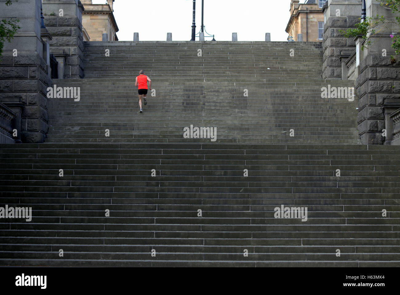 Male runner running up the steps park circus area of Glasgow Stock ...