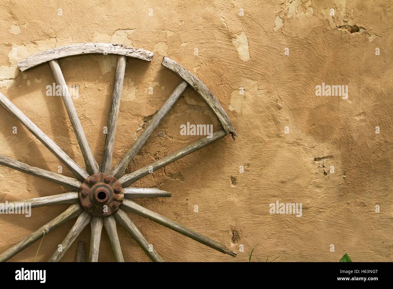 wooden, old broken wheel based on a clay wall decor old house Stock ...