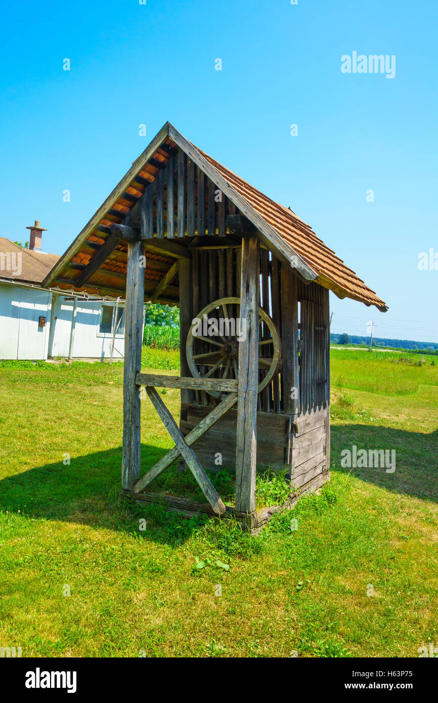 A water well with a wooden pumping wheel, in the village Krapje ...