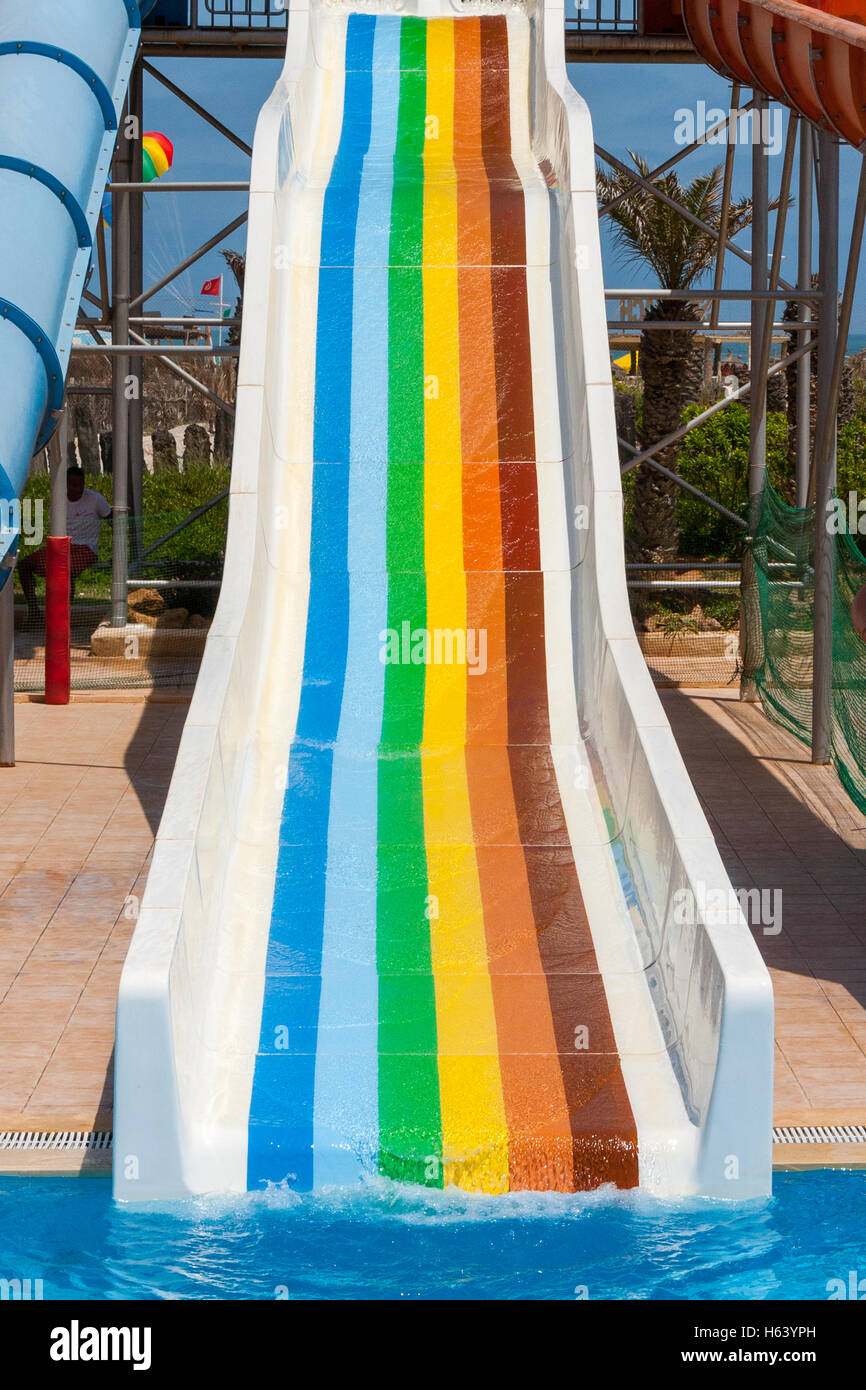 rainbow coloured water slide in water park Stock Photo - Alamy