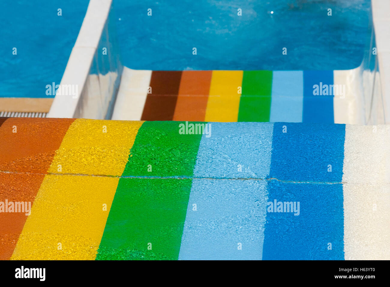 rainbow coloured water slide in water park Stock Photo - Alamy