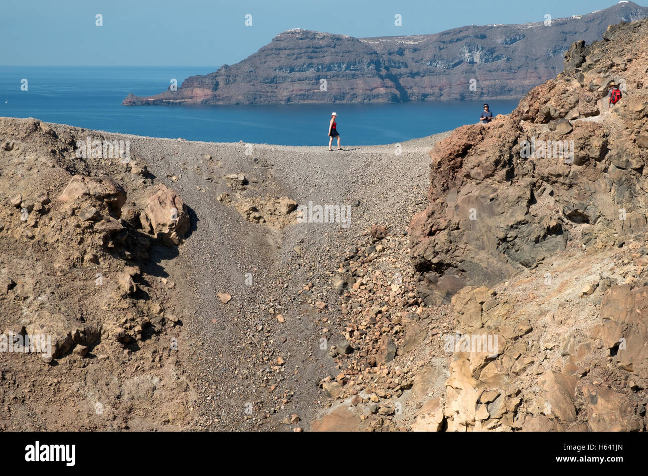 A tourist walks on the volcano in Santorini's caldera in the Aegean Sea ...