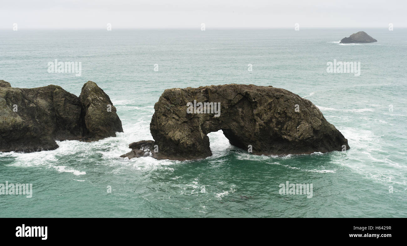 Surf crashes up against Arch Rock off the Oregon Coast Stock Photo - Alamy