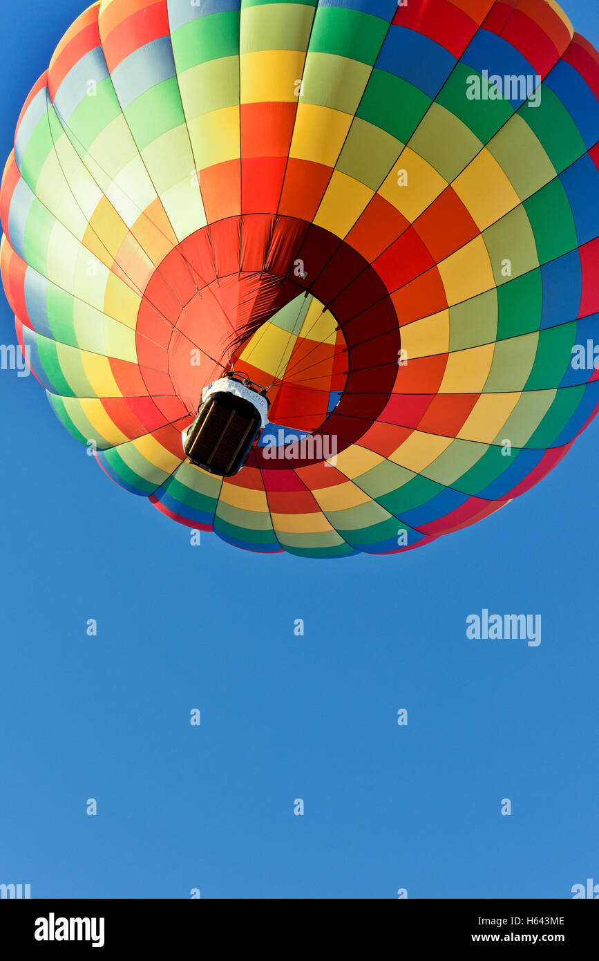 A hot air balloon rising with bright blue sky Stock Photo - Alamy