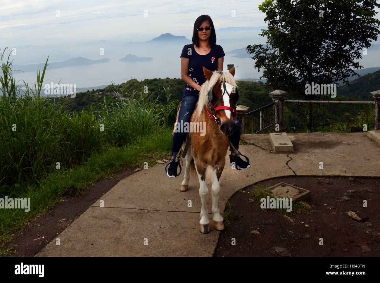 A Pinoy woman riding a horse in Taal volcano Stock Photo - Alamy
