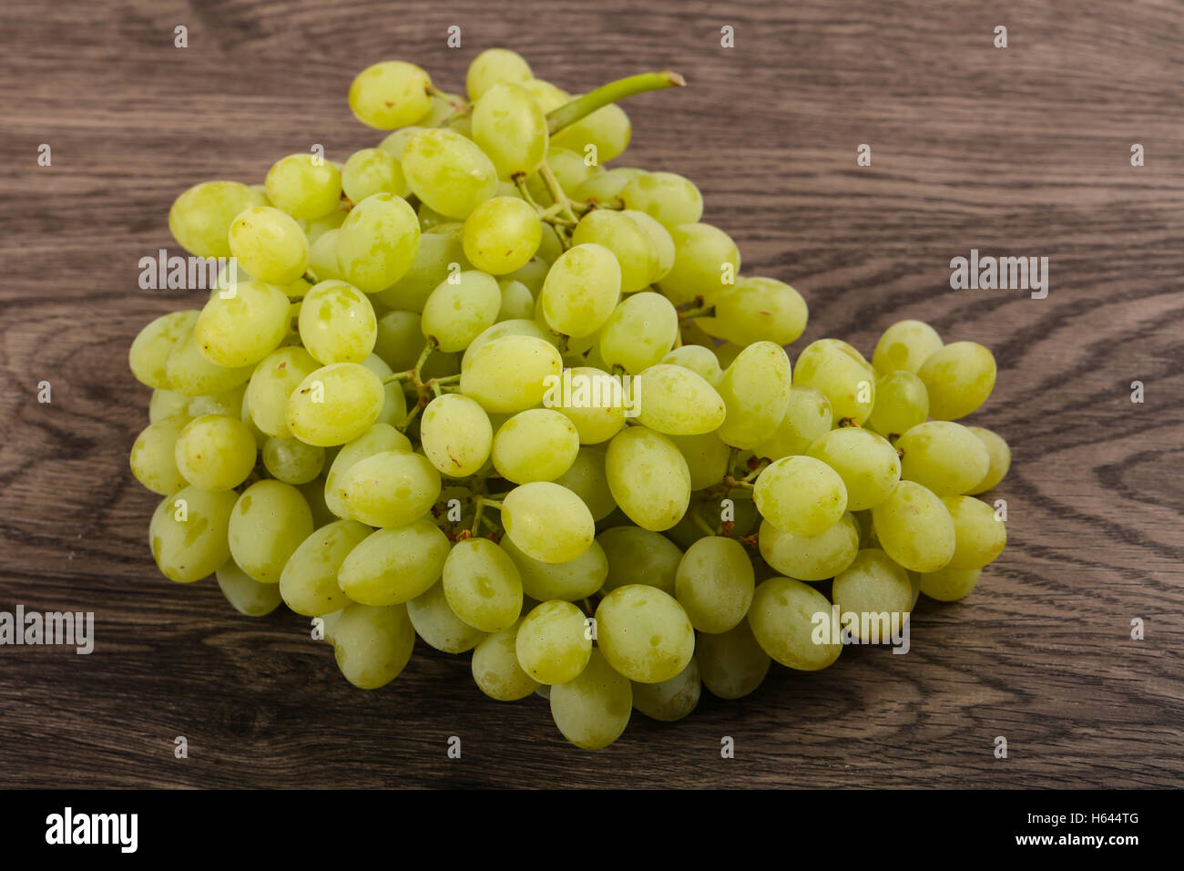 Sweet yellow grape heap on the wood background Stock Photo - Alamy