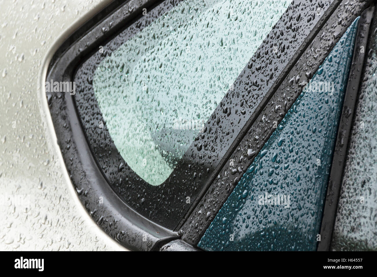 Extreme abstract close up view of wet vehicle side window with droplets ...
