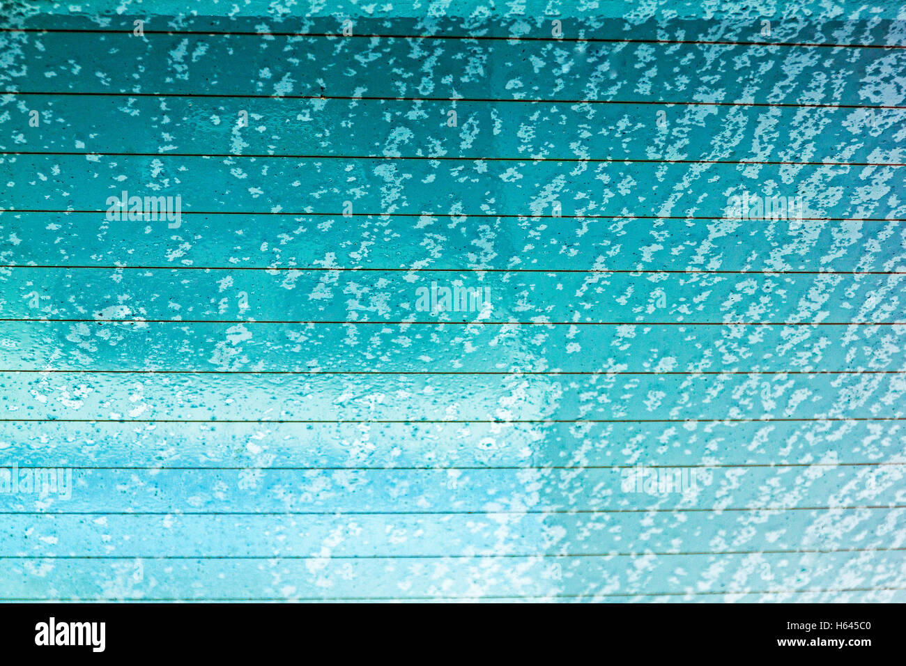 Extreme abstract close up of vehicle wet rear windshield and defrosting ...