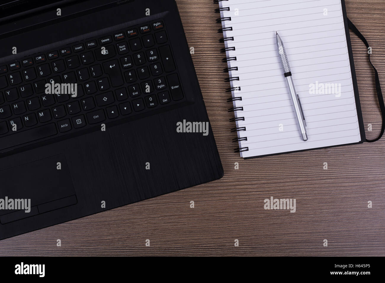 Lay flat image of an open notebook and laptop on a wooden surface Stock ...