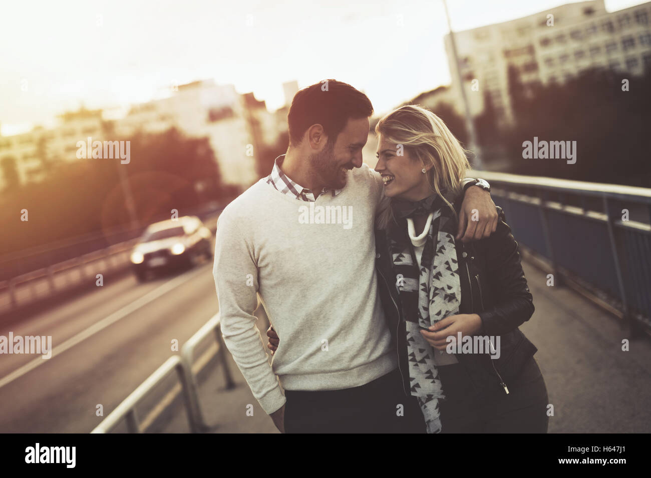 Couple kissing dating on bridge during sunset Stock Photo - Alamy