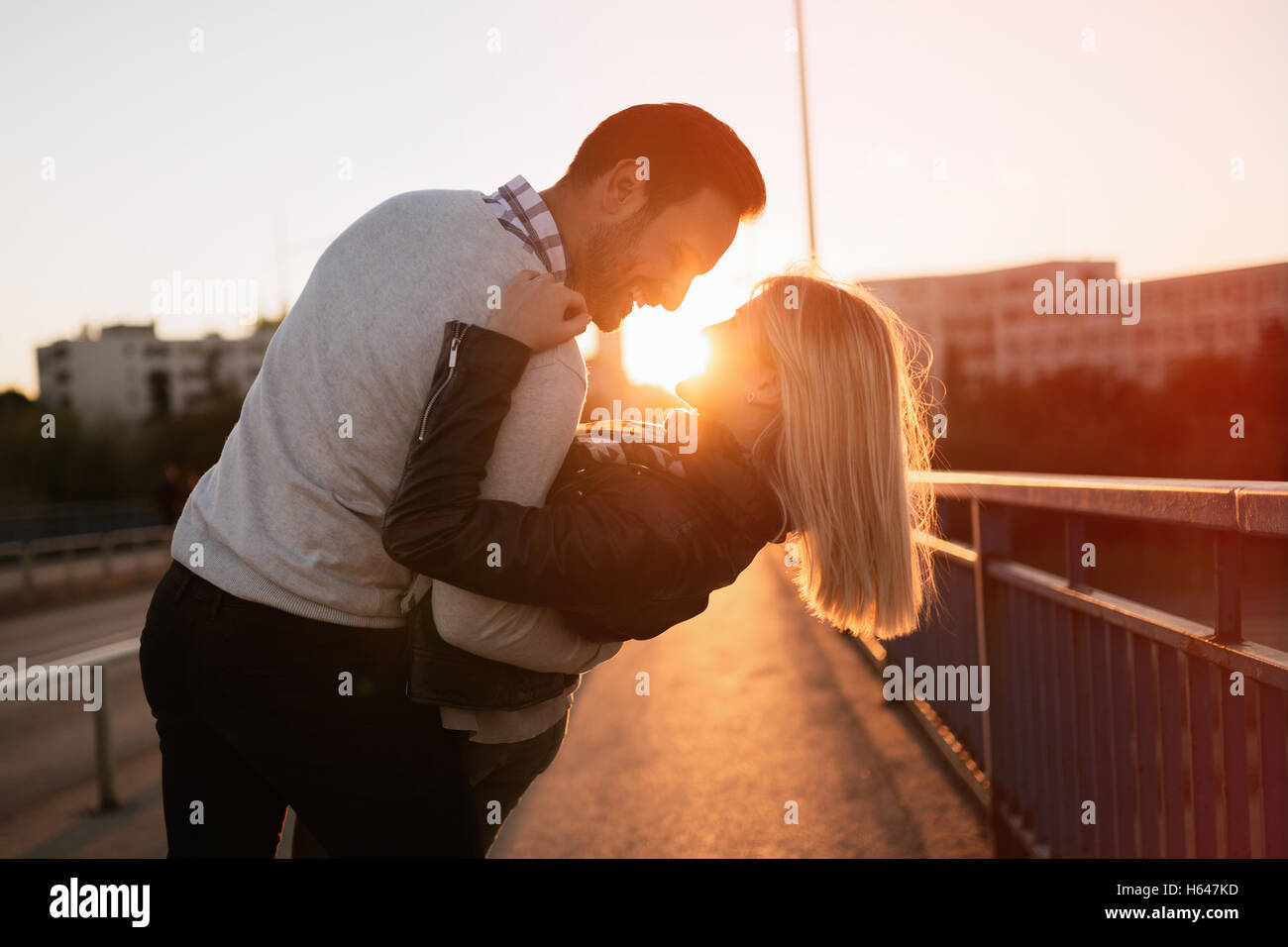 Romantic couple kissing in city during sunset Stock Photo - Alamy