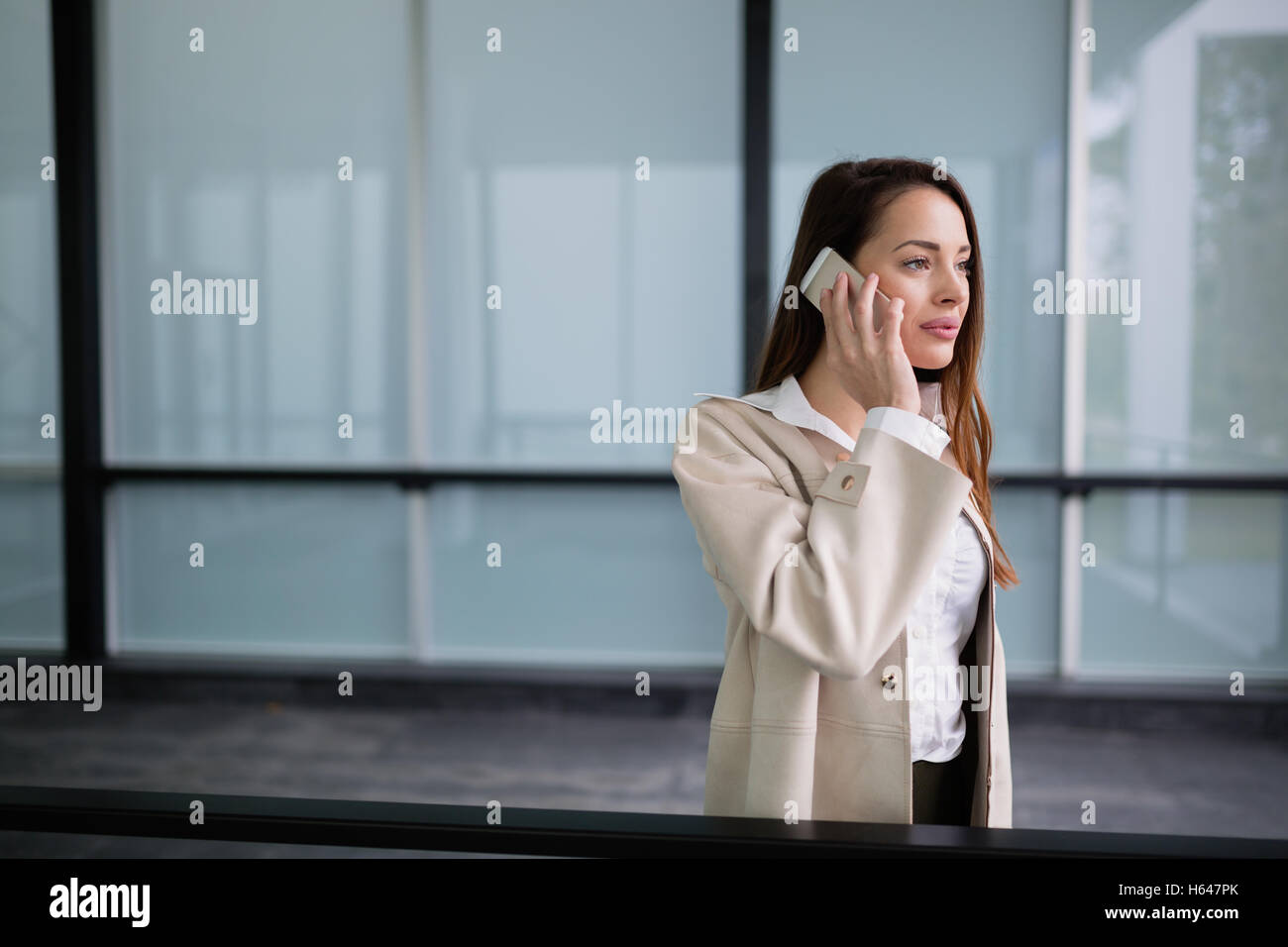 Serious businesswoman using phone at the offices Stock Photo - Alamy