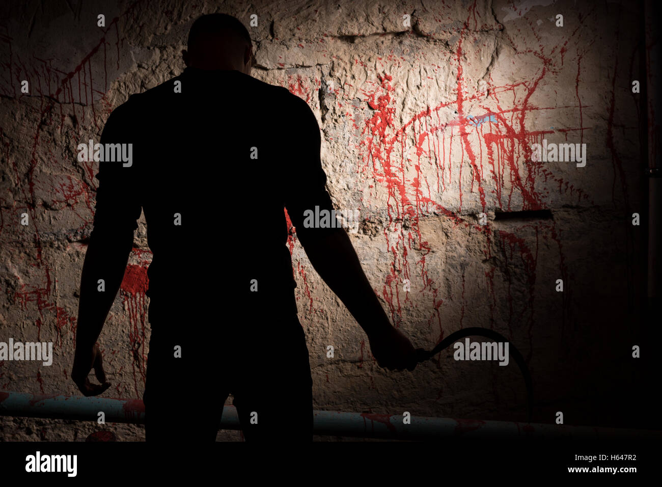 Shadowy figure holding blade near blood stained wall for concept about ...