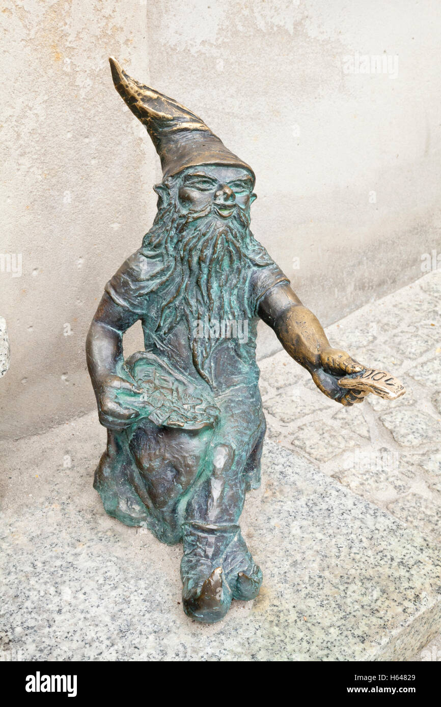 A bronze statue of a gnome holding out money in commemoration of the ...