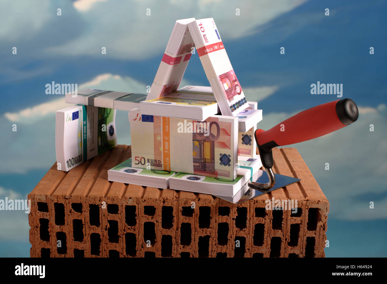 House made of bundles of banknotes, trowel, brick, symbolic image for ...