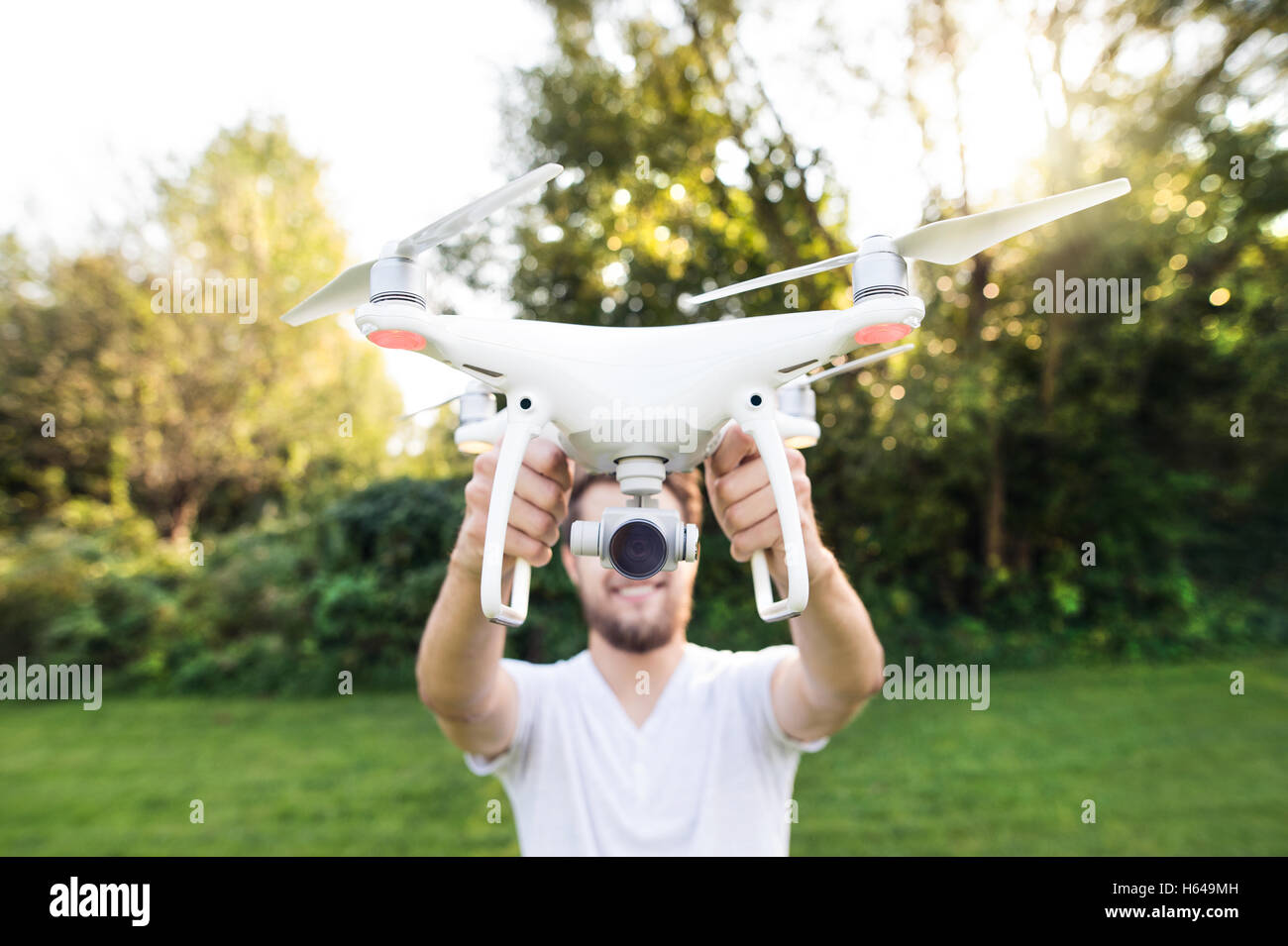 Young hipster man holding drone. Sunny green nature Stock Photo - Alamy