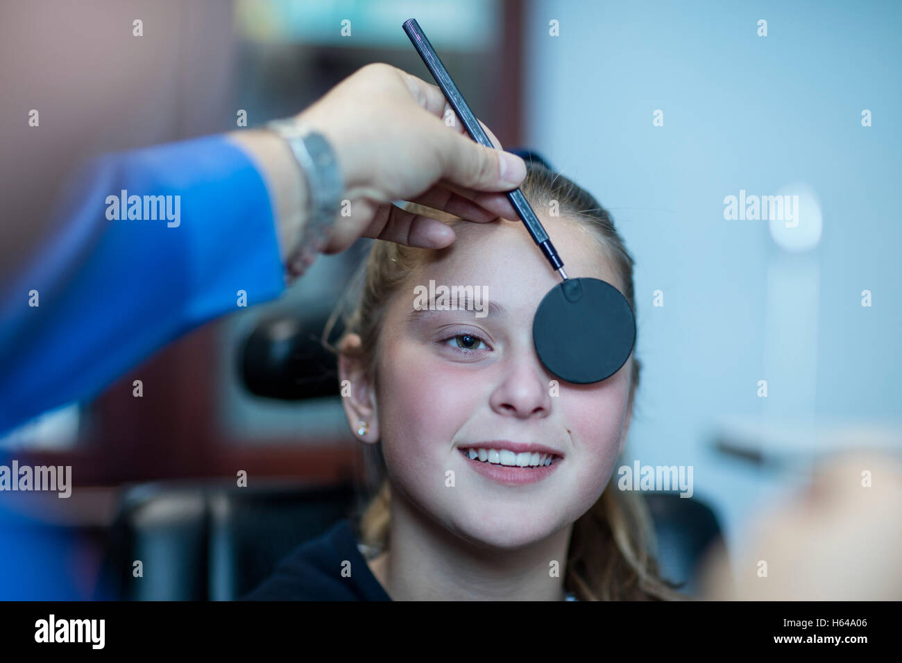 Girl doing eye test at optometrist Stock Photo - Alamy
