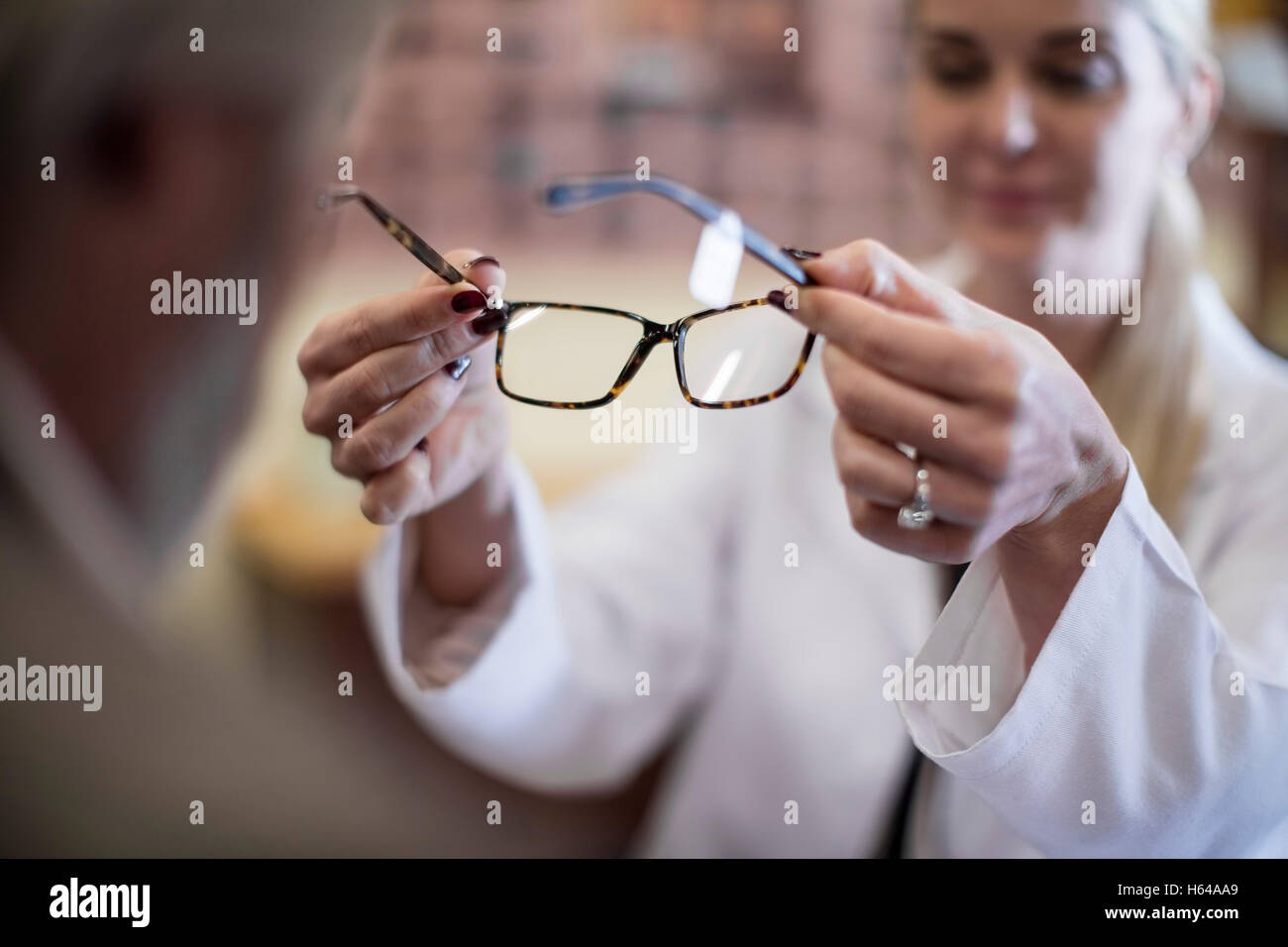 Optician helping customer to choose new spectacles Stock Photo - Alamy