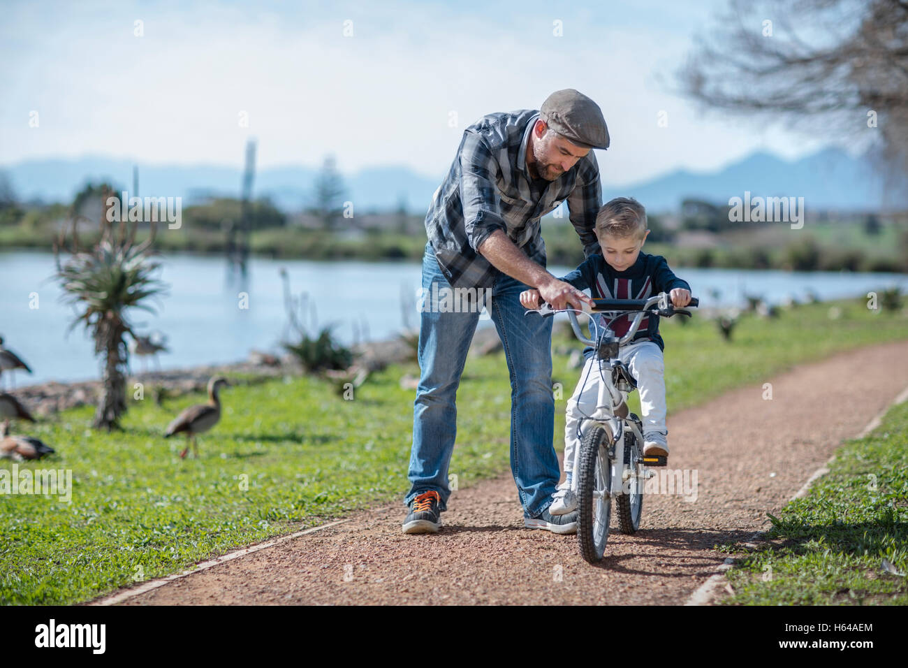 Father supporting son on bike Stock Photo - Alamy
