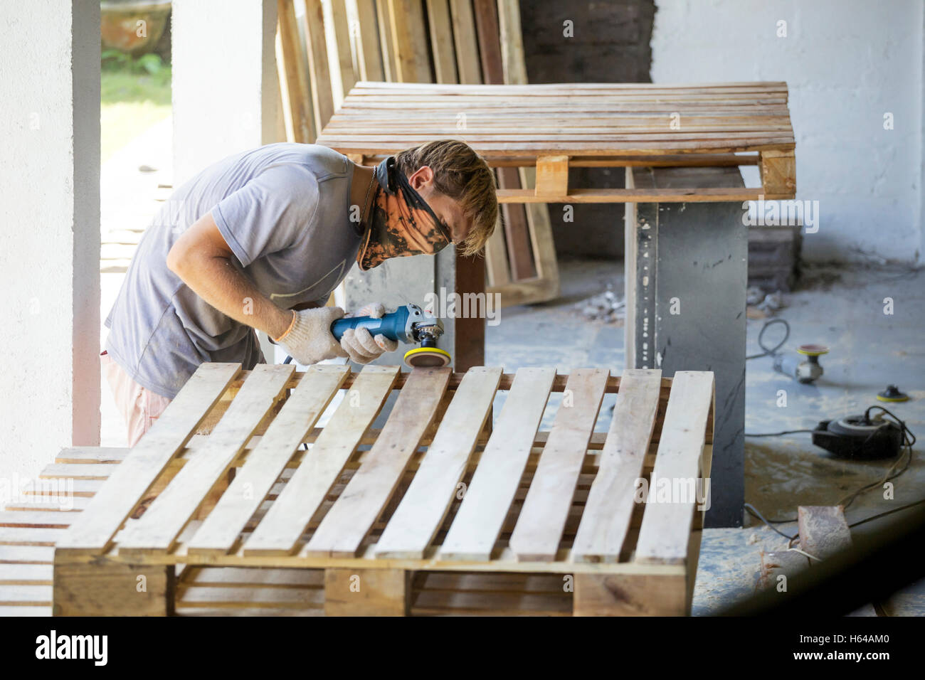 Man sanding pallet with a random orbital sander Stock Photo - Alamy