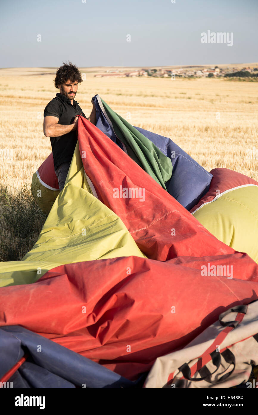 Man packing up a hot air balloon envelope Stock Photo - Alamy