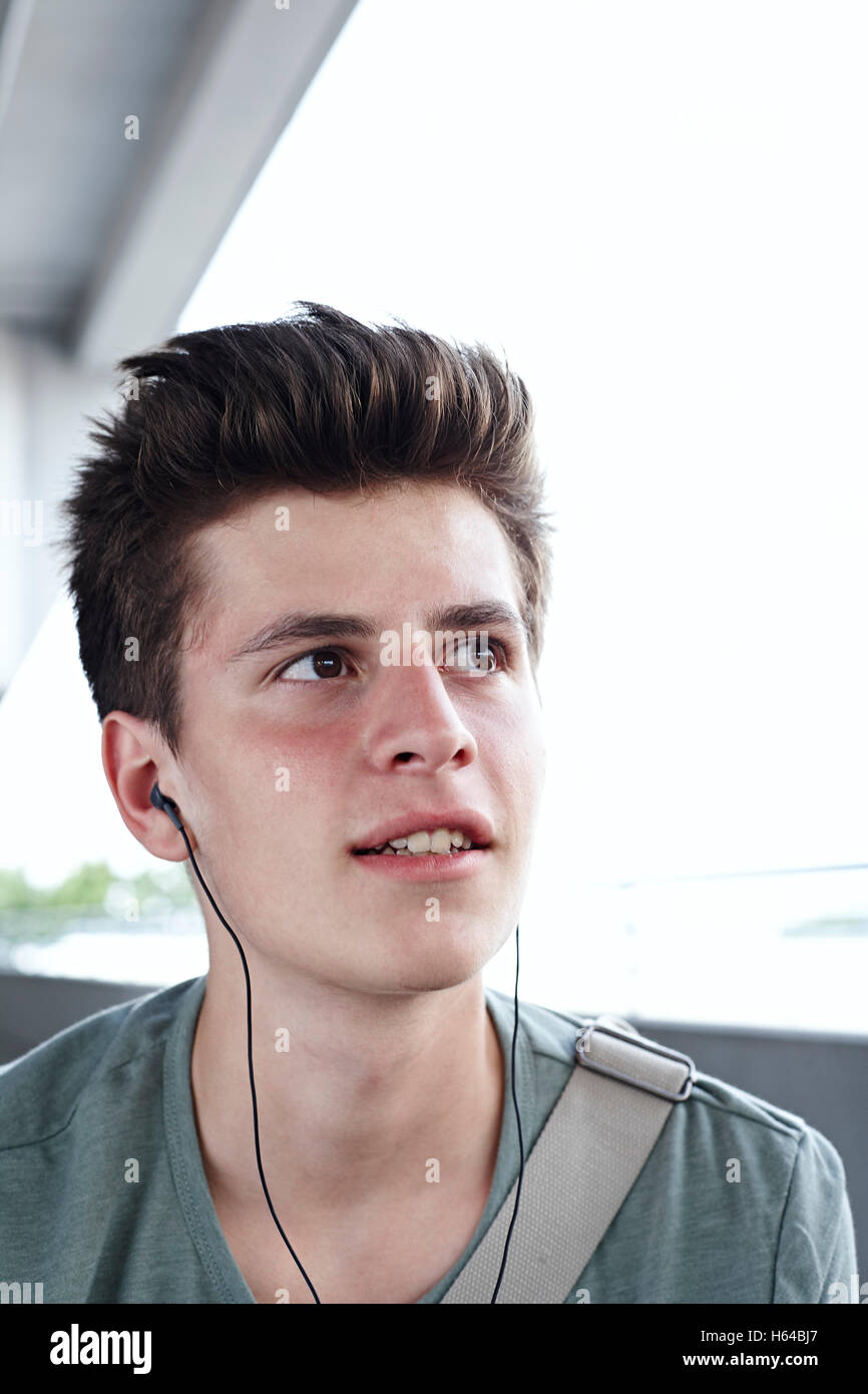 Teenage boy with earbuds outdoors Stock Photo - Alamy