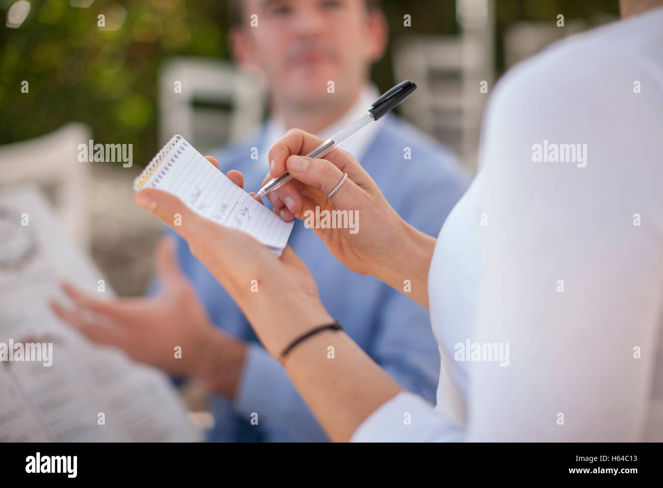 Waitress writing ordering on notepad, partial view Stock Photo - Alamy