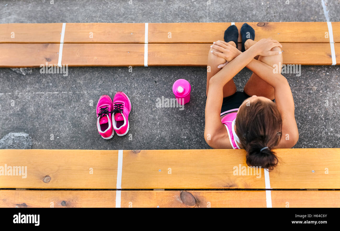 Female athlete taking a break, sitting in stadium Stock Photo - Alamy