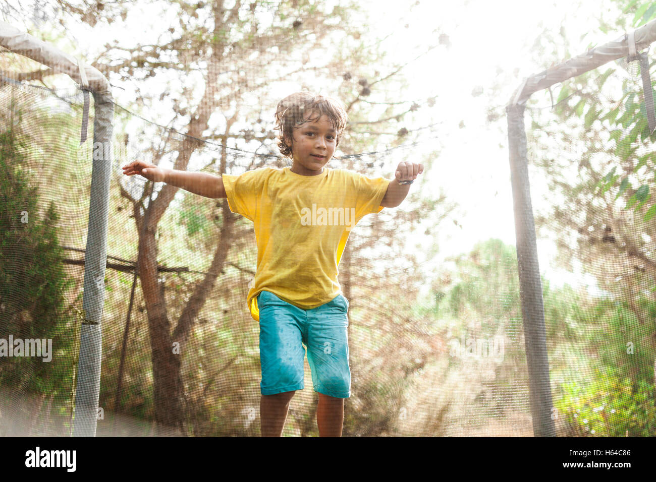 Little boy jumping on trampoline Stock Photo - Alamy