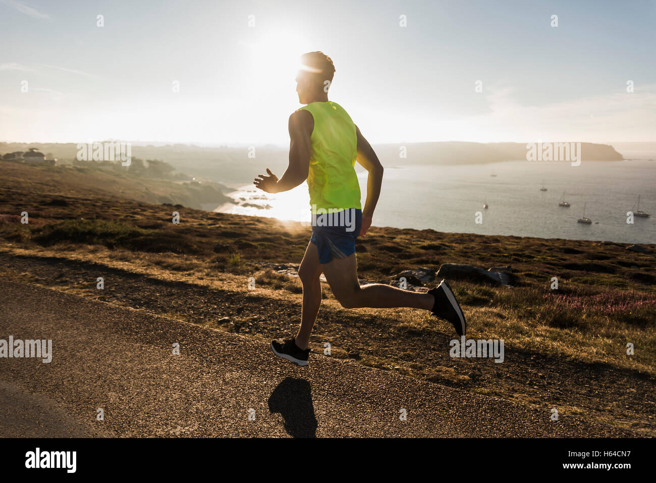 France, Crozon peninsula, young man running on coastal road Stock Photo ...