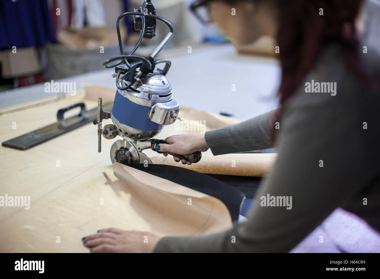 Seamstress cutting cloth in factory Stock Photo - Alamy