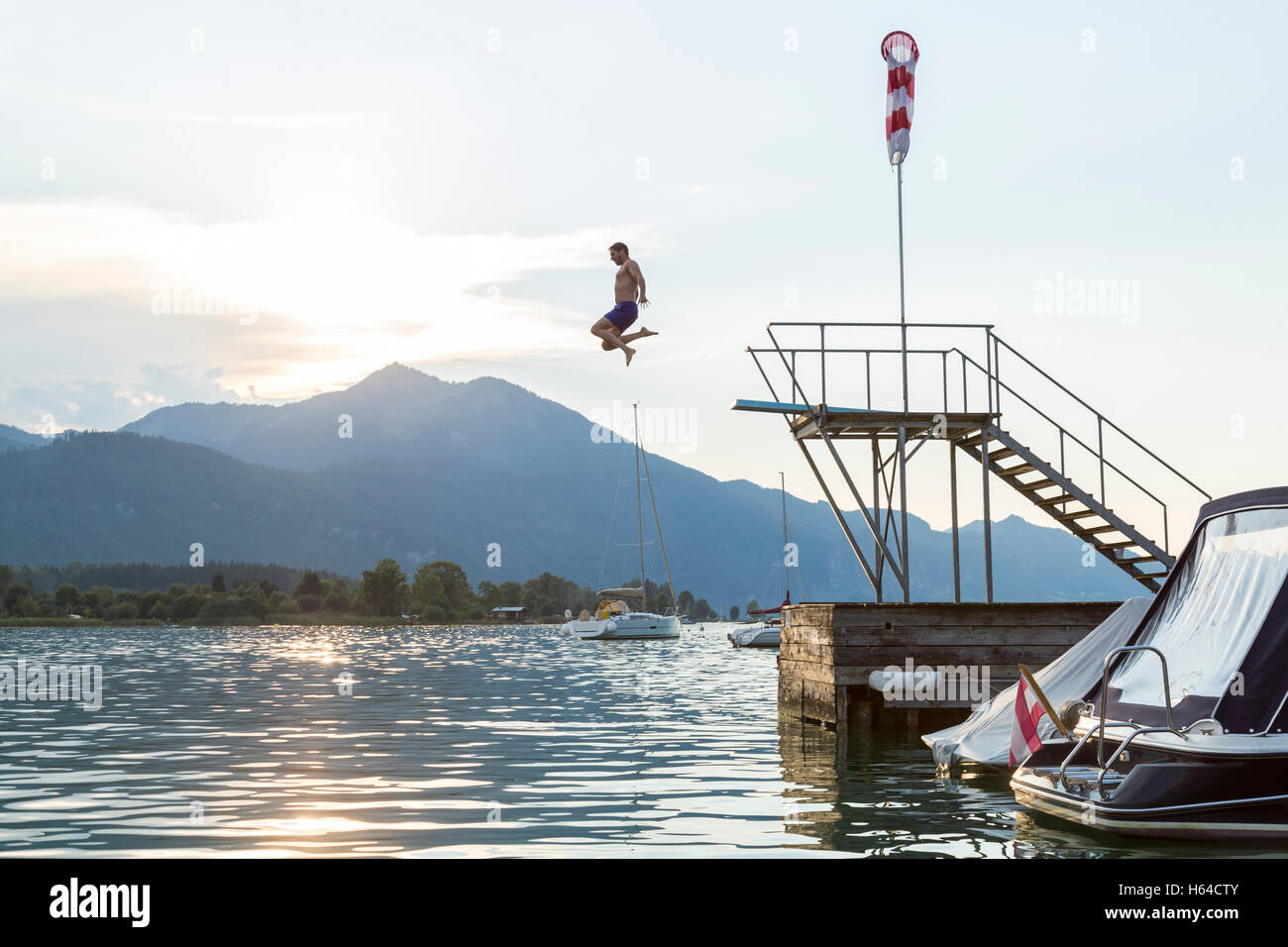 Austria, Sankt Wolfgang, man jumping from platform into lake Stock ...