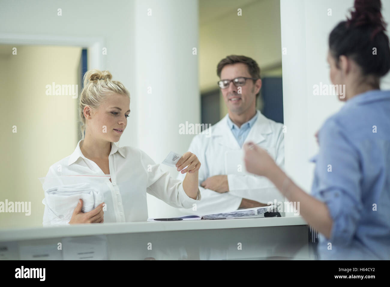Woman receiving name tag at reception Stock Photo - Alamy