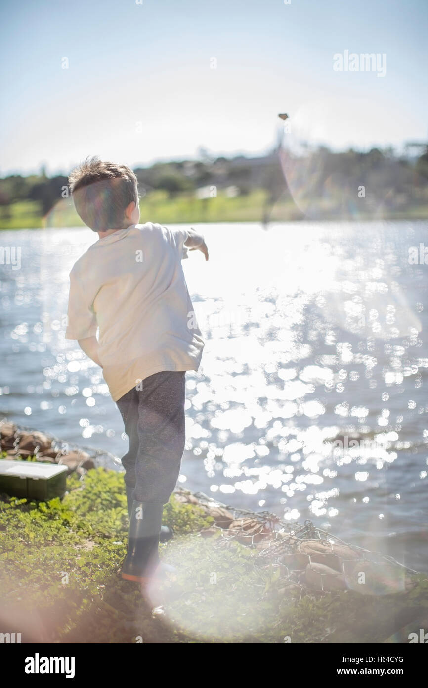 Boy throwing stones in a lake Stock Photo - Alamy