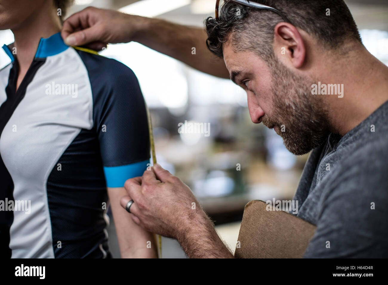 Tailor measuring arm of model wearing sportswear Stock Photo - Alamy