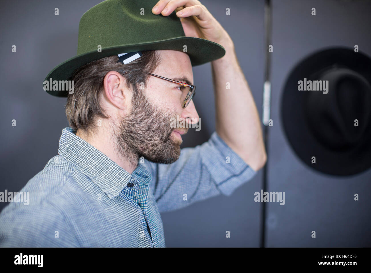 Man in shop trying on hat Stock Photo - Alamy