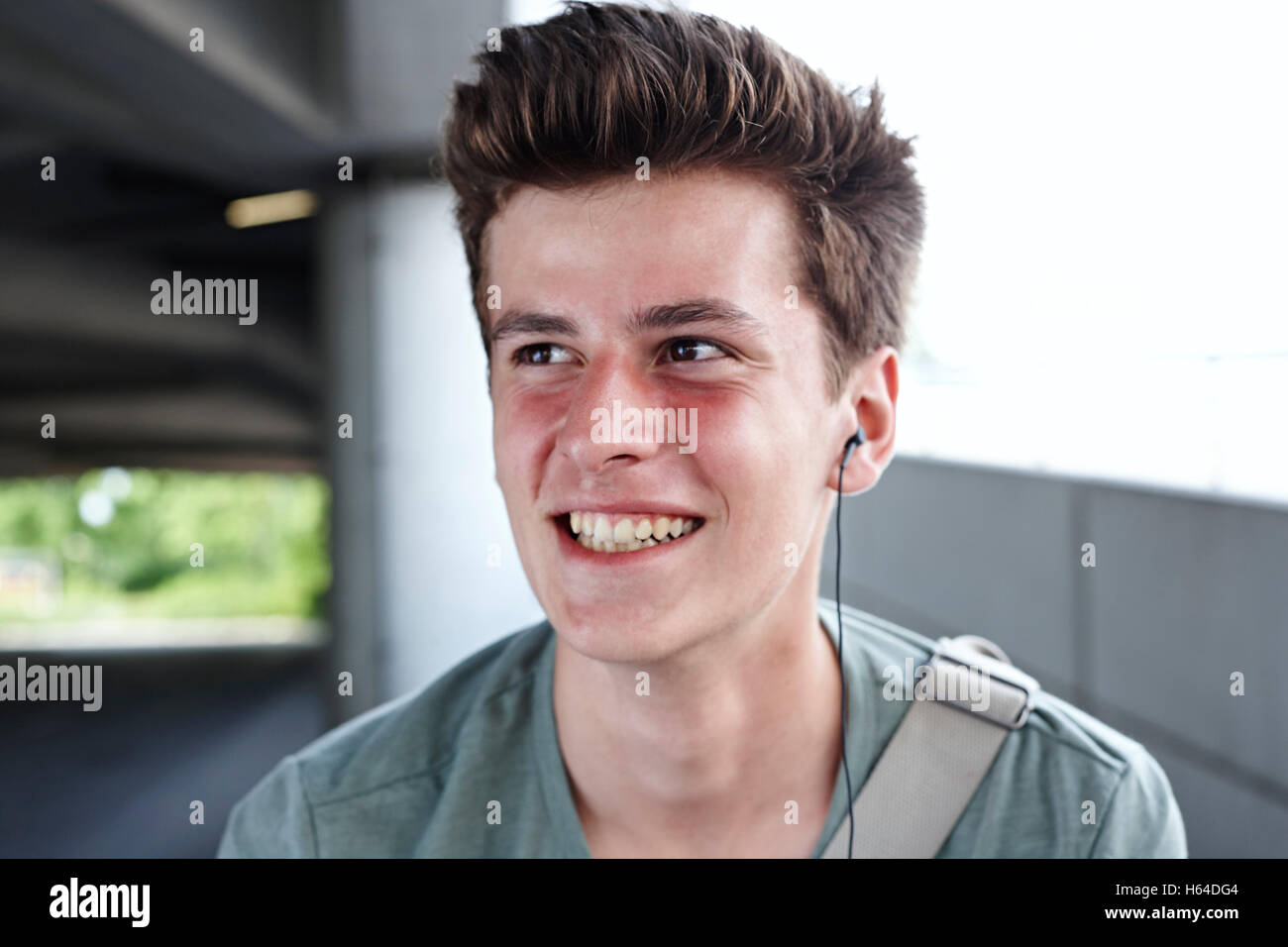 Smiling teenage boy with earbuds outdoors Stock Photo - Alamy