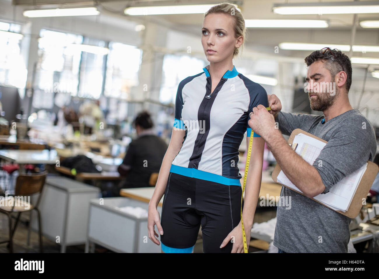 Tailor measuring arm of model wearing sportswear Stock Photo - Alamy