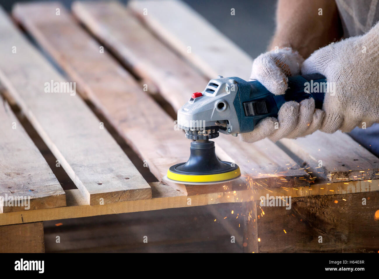Man sanding pallet with a random orbital sander Stock Photo - Alamy