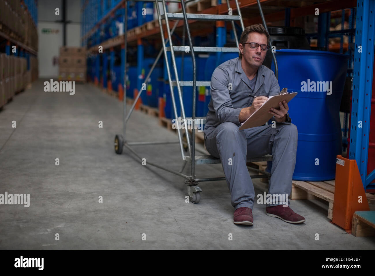 Worker taking stock in warehouse Stock Photo - Alamy