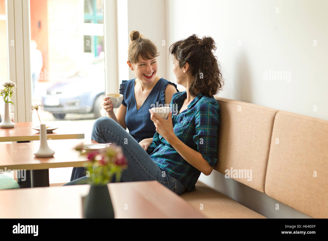Two happy friends in a coffee shop Stock Photo - Alamy