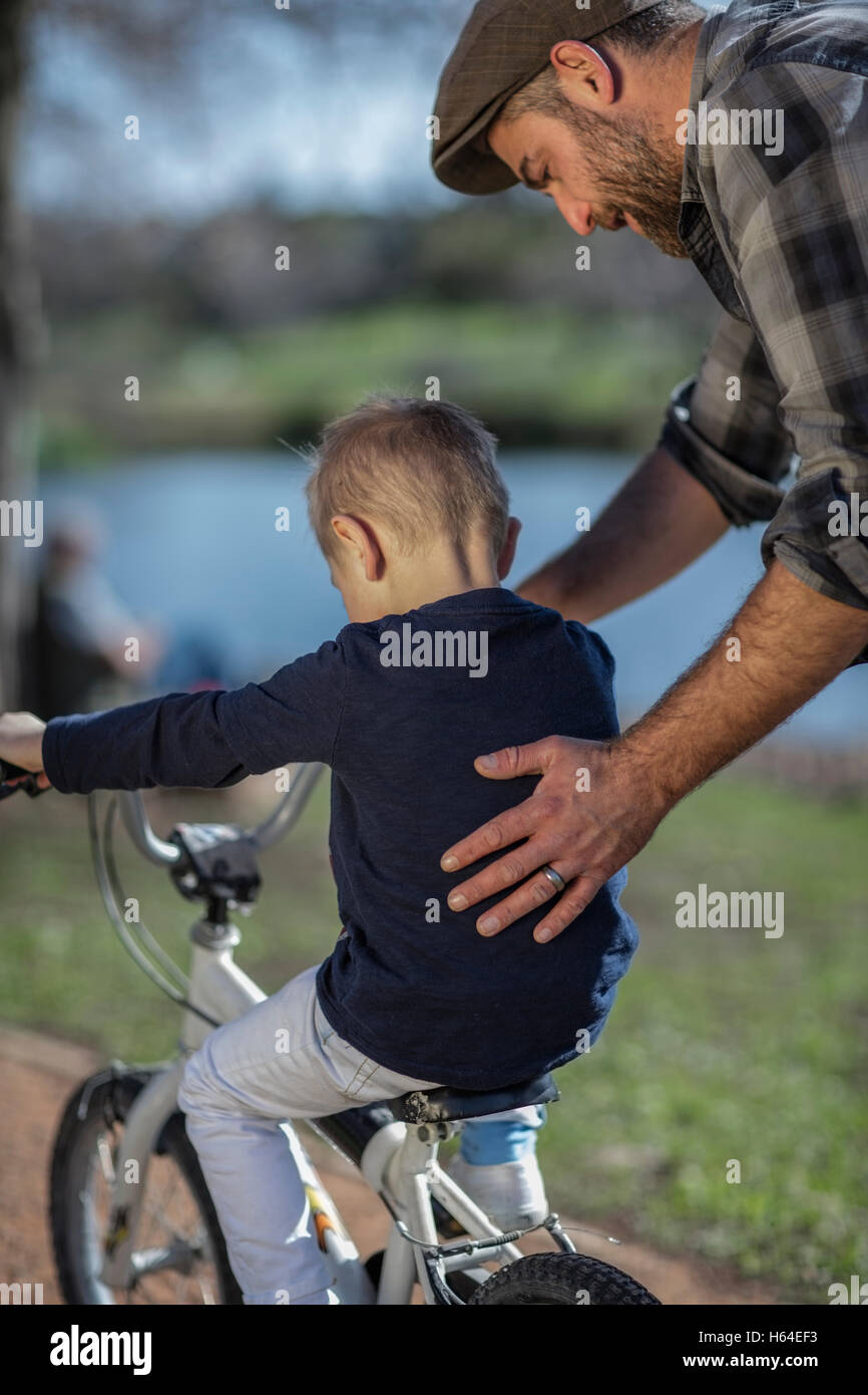 Father supporting son on bike Stock Photo - Alamy