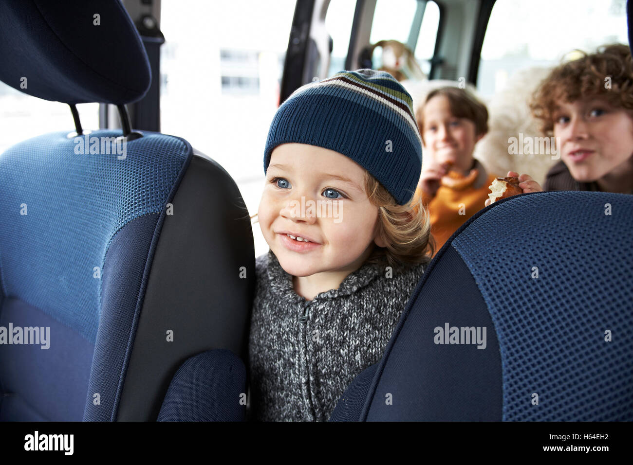 Little boy sitting in car with brothers Stock Photo - Alamy