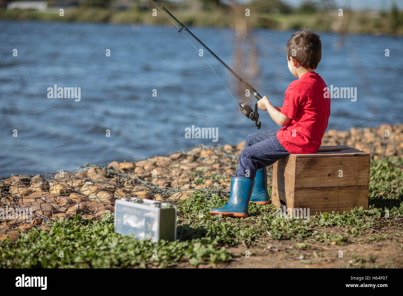 Little boy fishing in lake Stock Photo - Alamy