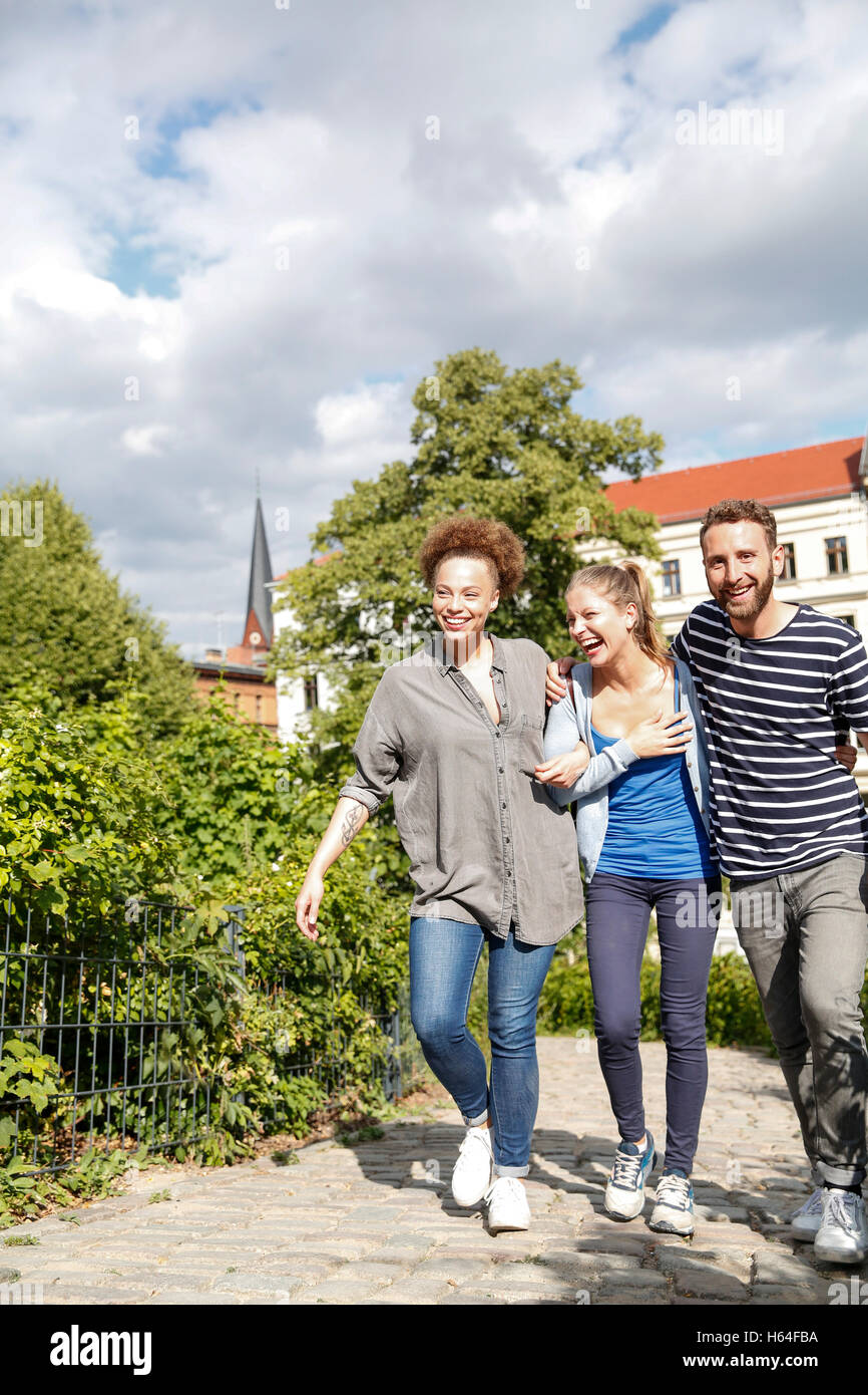 Happy friends walking in park Stock Photo - Alamy