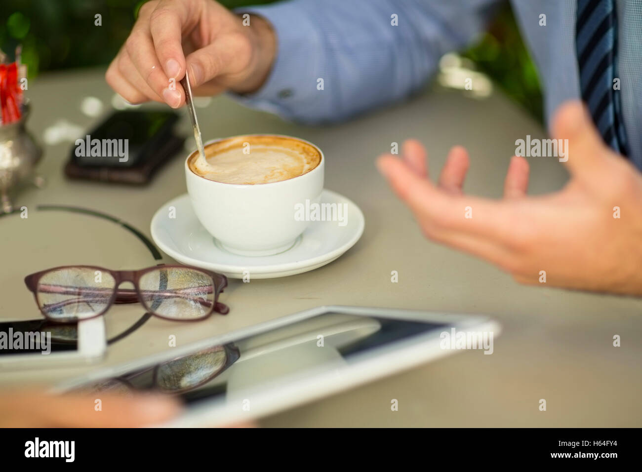 Businessman stirring coffee Stock Photo - Alamy