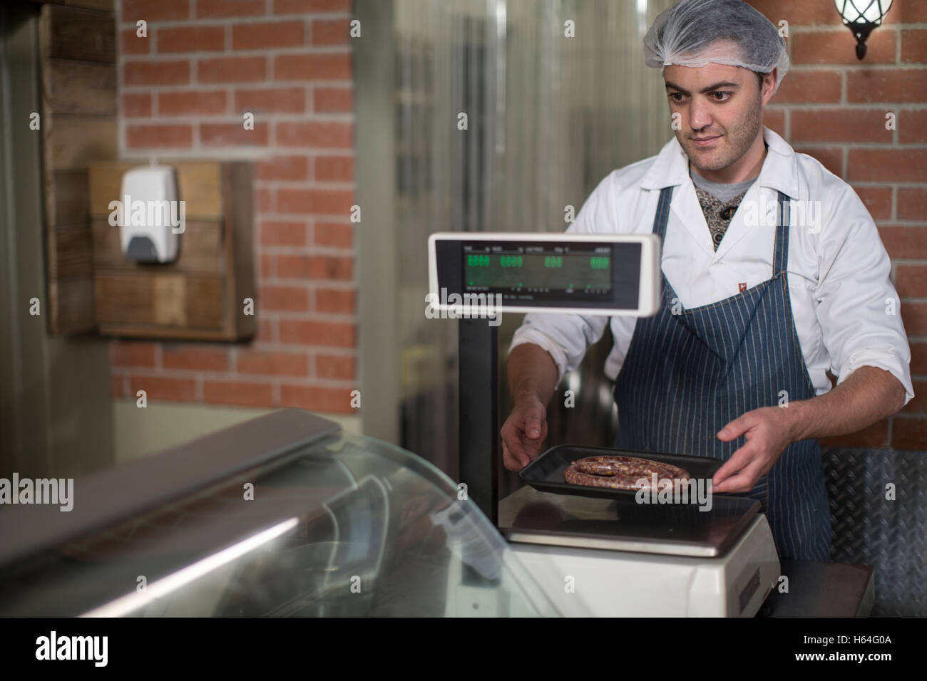 Butcher weighing sausage on scale Stock Photo - Alamy