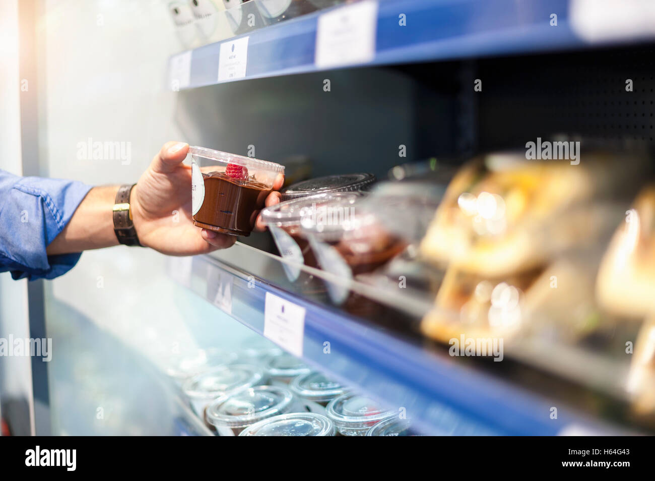 Hand taking food from cooling shelf Stock Photo - Alamy