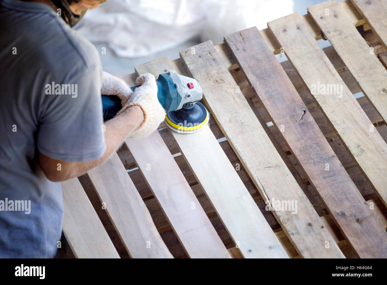 Man sanding pallet with a random orbital sander Stock Photo - Alamy